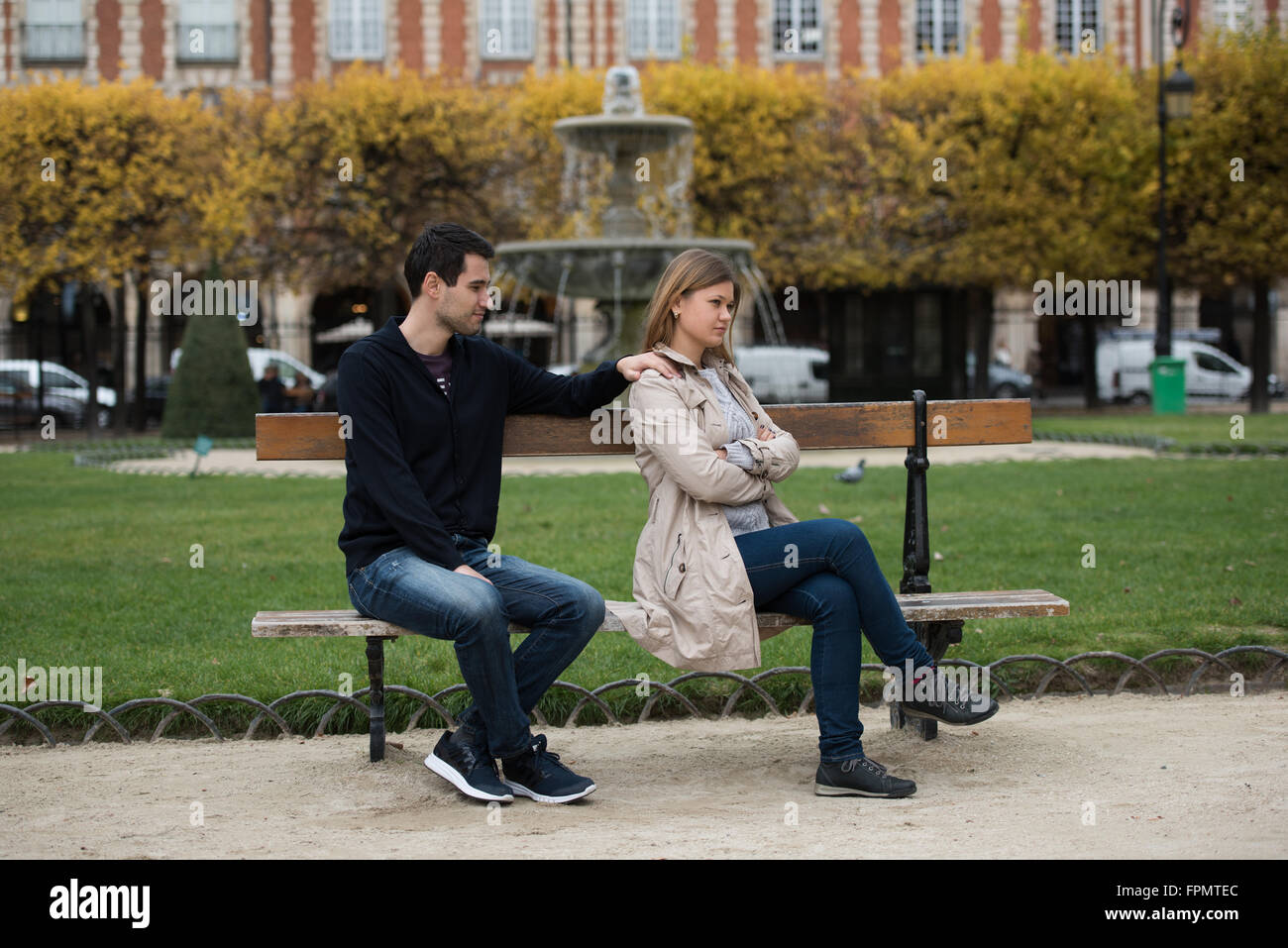 young couple having romantic conversation after love fight on the bench ...
