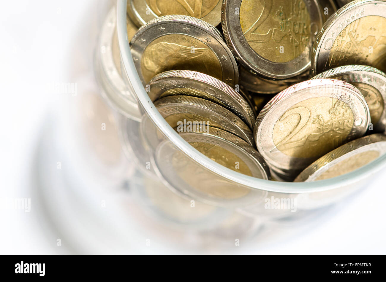 coins in glass on white background Stock Photo - Alamy