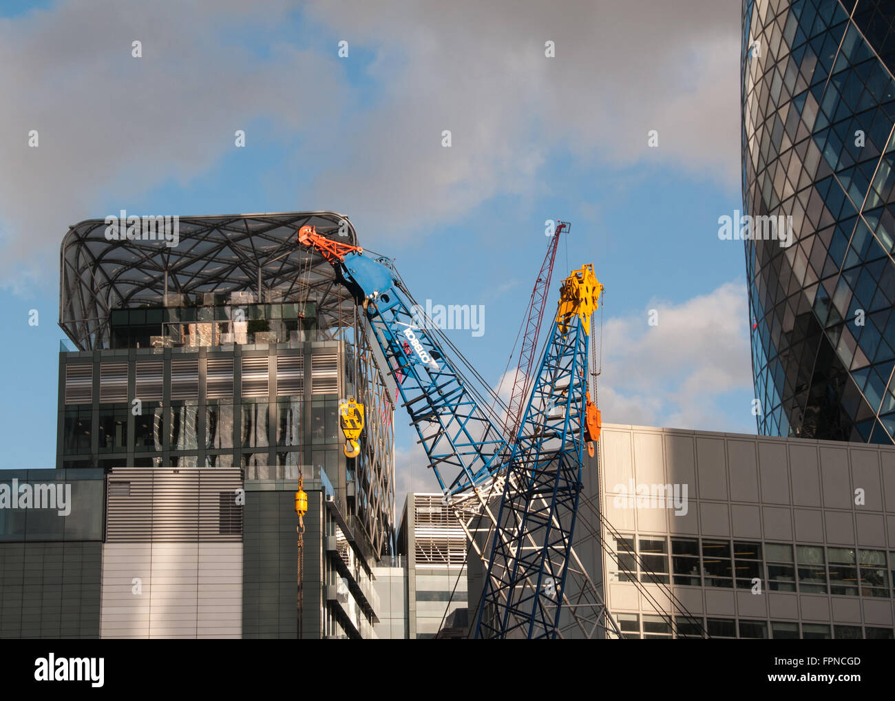 London under construction metal cranes and Gherkin on sunny day, UK ...