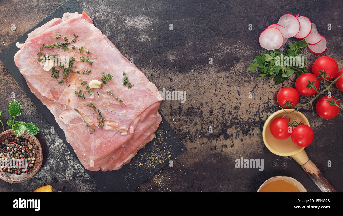 Fresh raw meat with thyme and spices ready for roasting . Top view ...