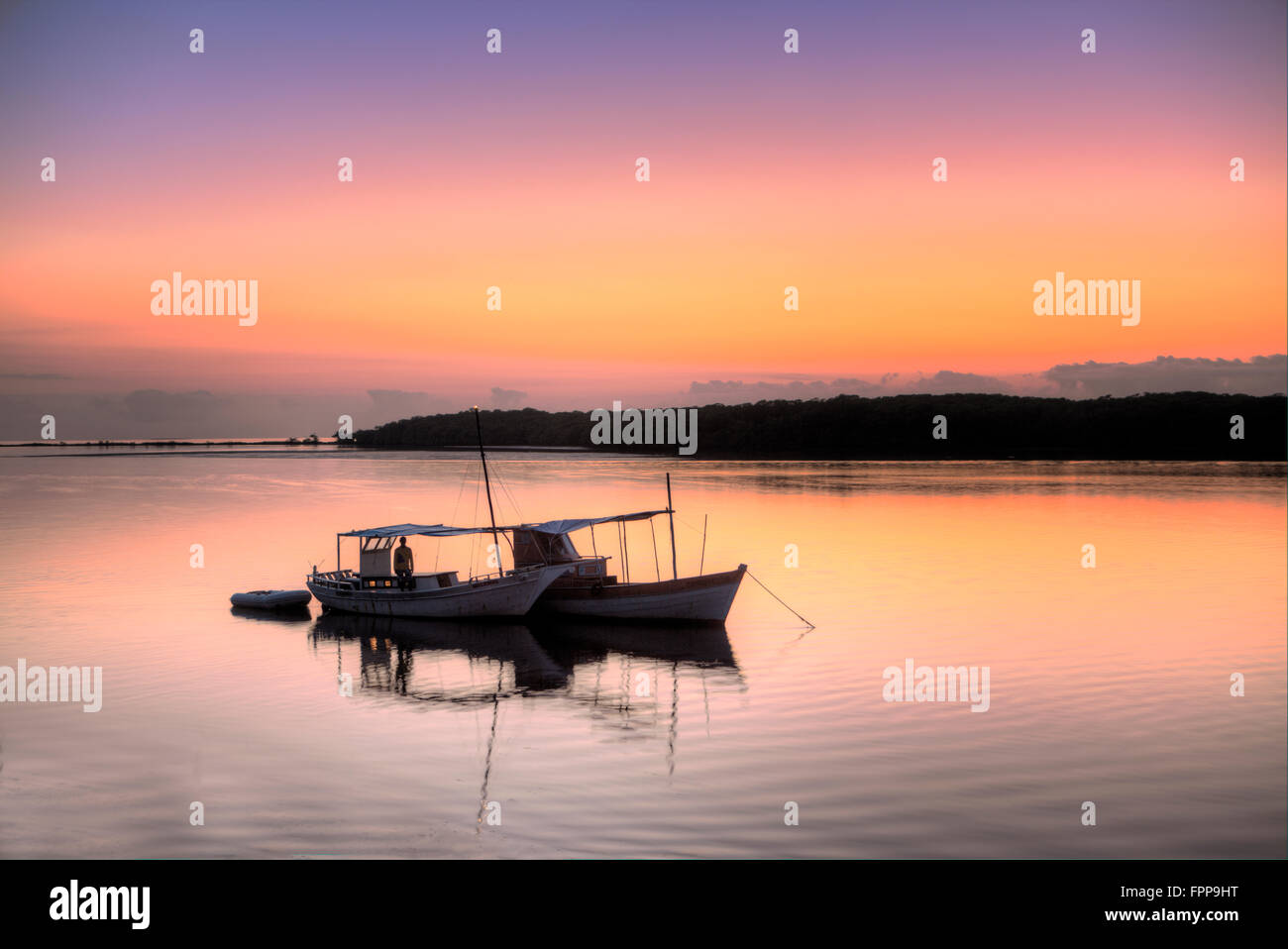 Fishing boat at sunset Stock Photo - Alamy