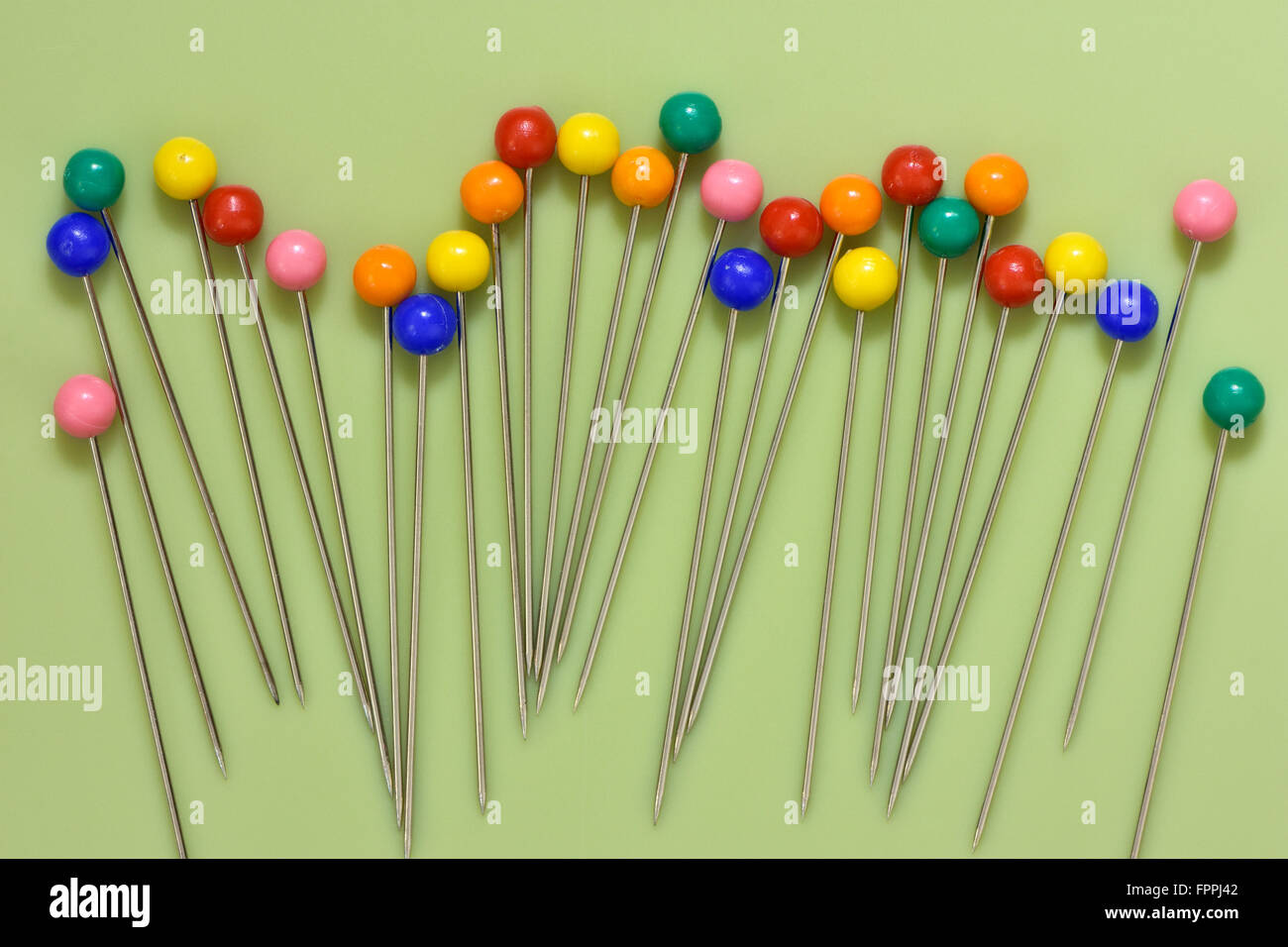 Colourful berry pins on green background Stock Photo - Alamy