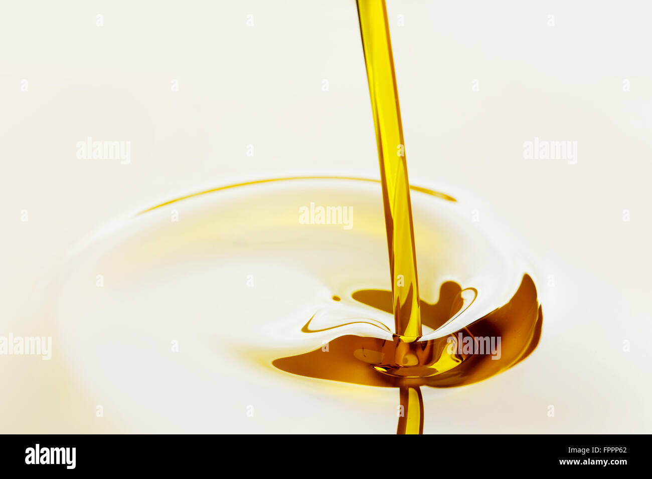 Pouring liquid golden oil close up view Stock Photo - Alamy