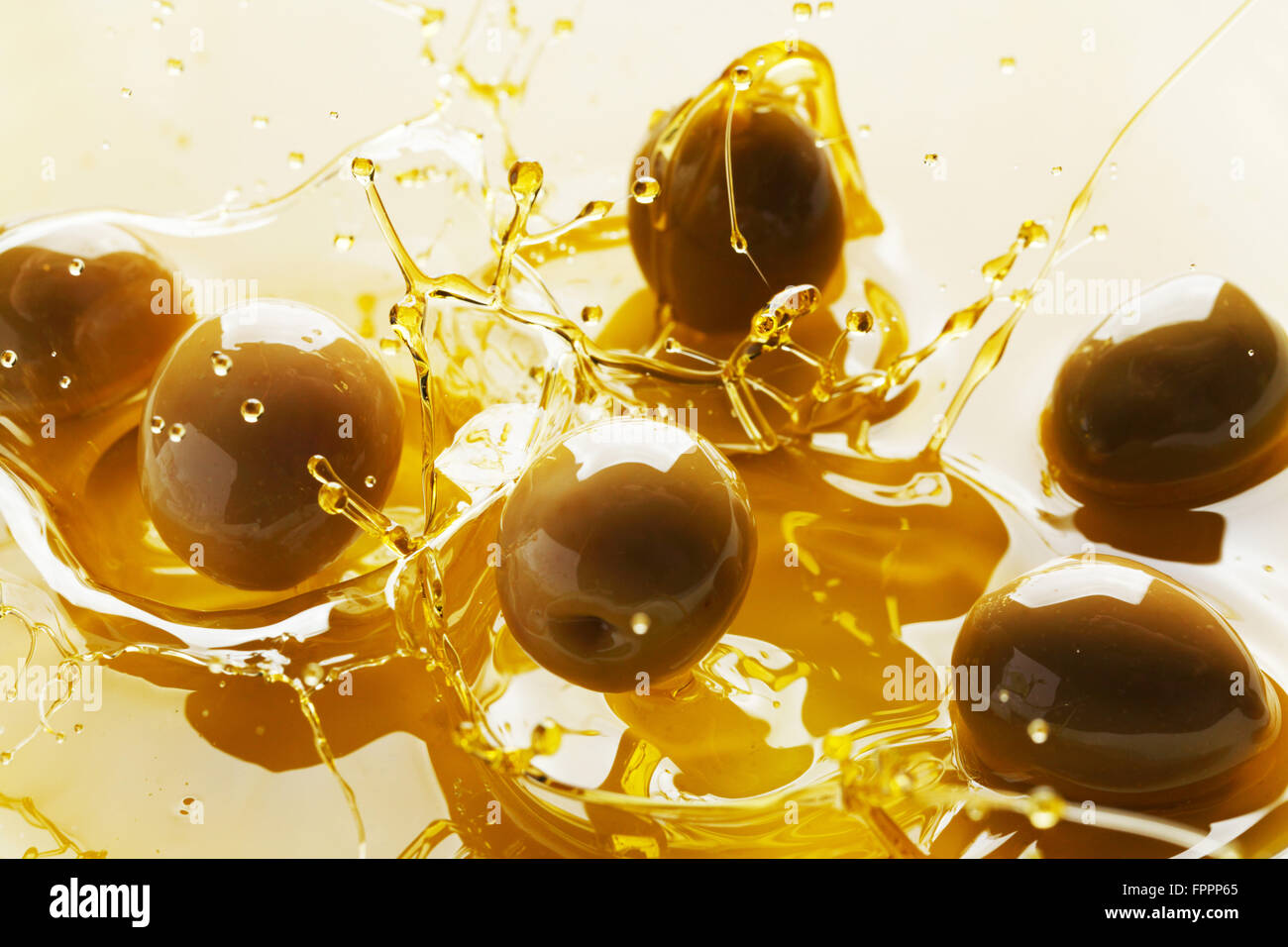 Splash of olive fruits in oil close-up view Stock Photo - Alamy