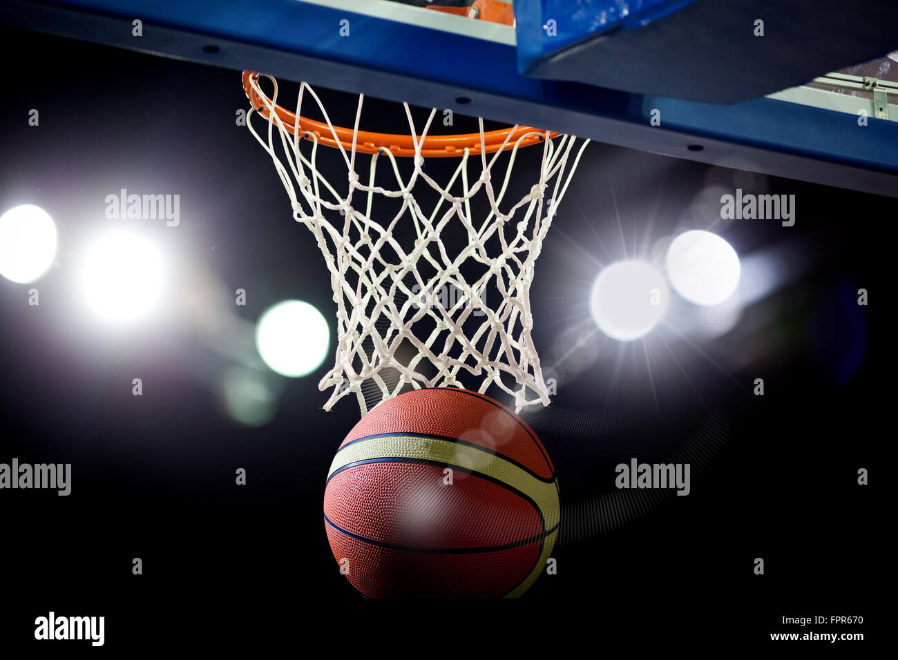 Basketball going through the hoop at a sports arena (intentional ...