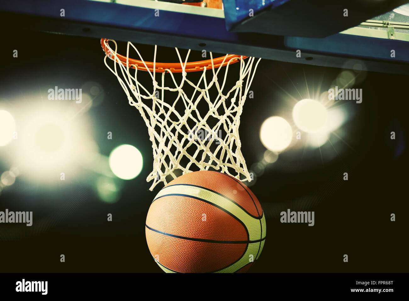 Basketball going through the hoop at a sports arena (intentional ...