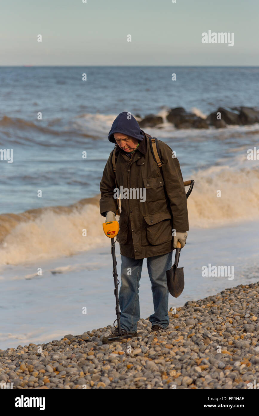 Treasure hunter on beach with metal detector Stock Photo - Alamy