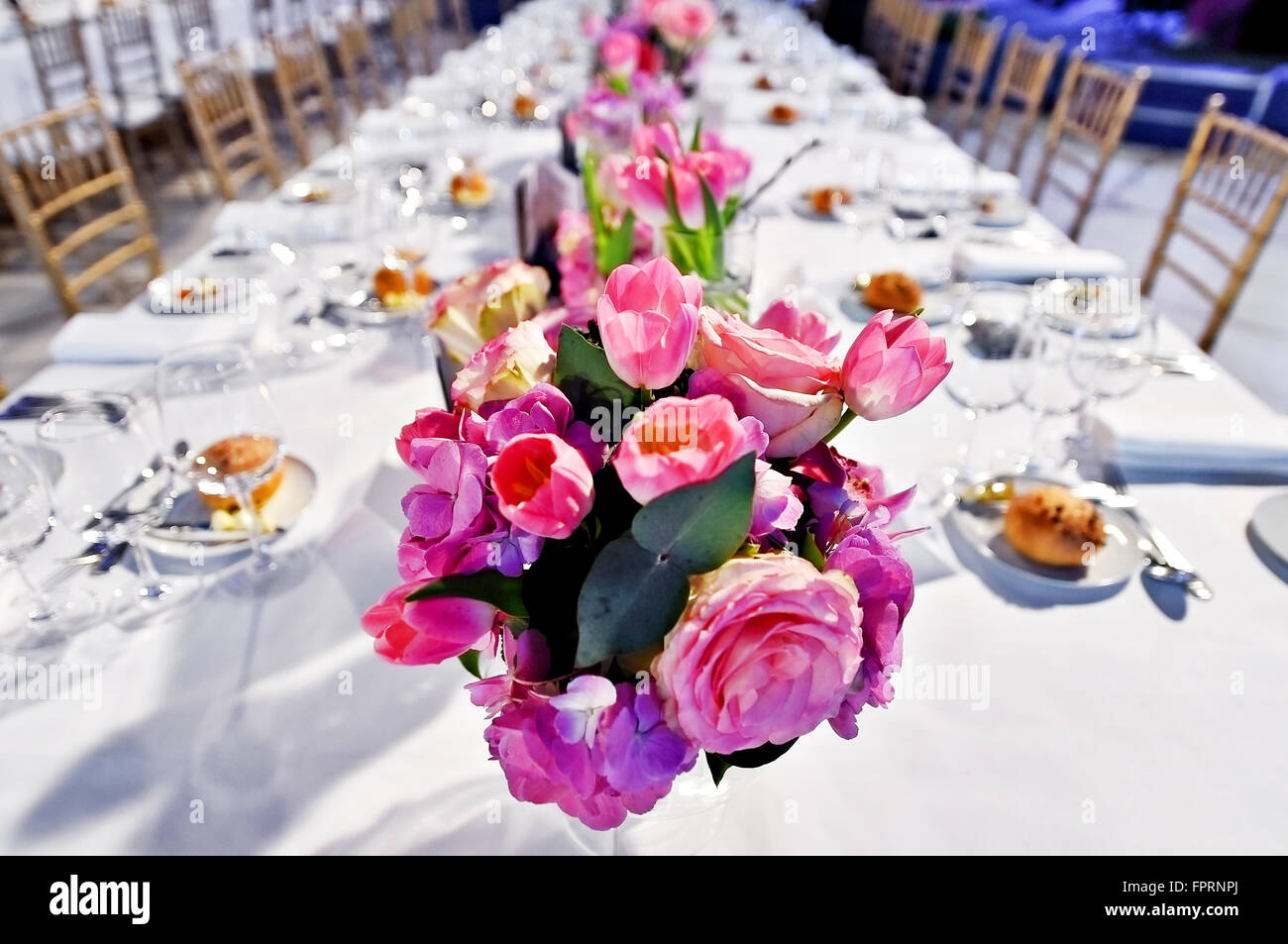 Festive dinner table with flowers bouquets and starters inside a ...