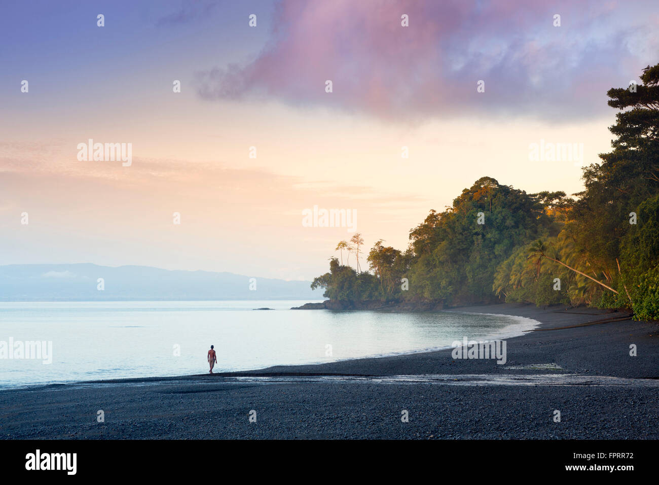 Figure on a wild and deserted volcanic black sand beach in the Golfo ...