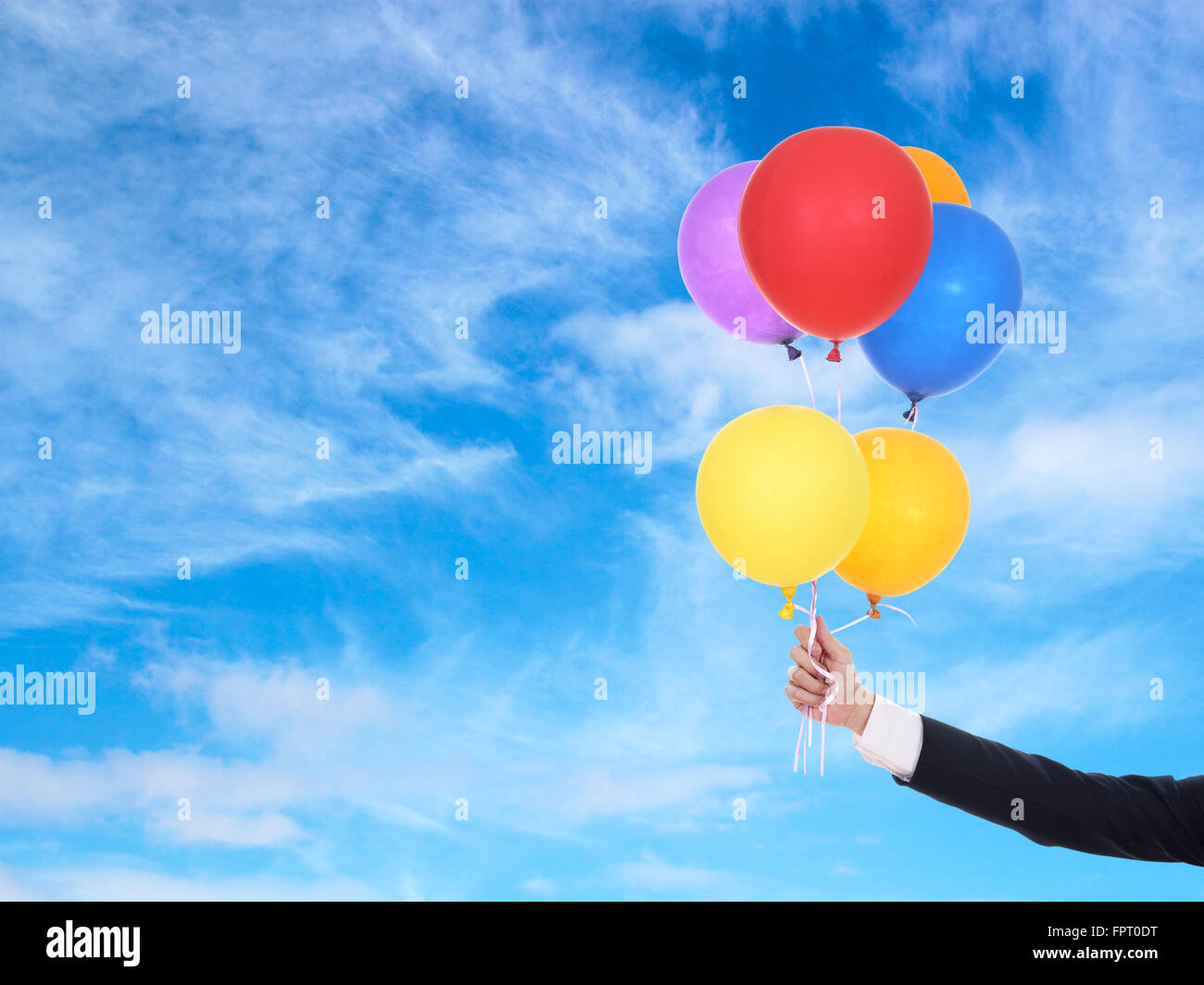 business hand holding colorful balloons with blue sky background Stock ...