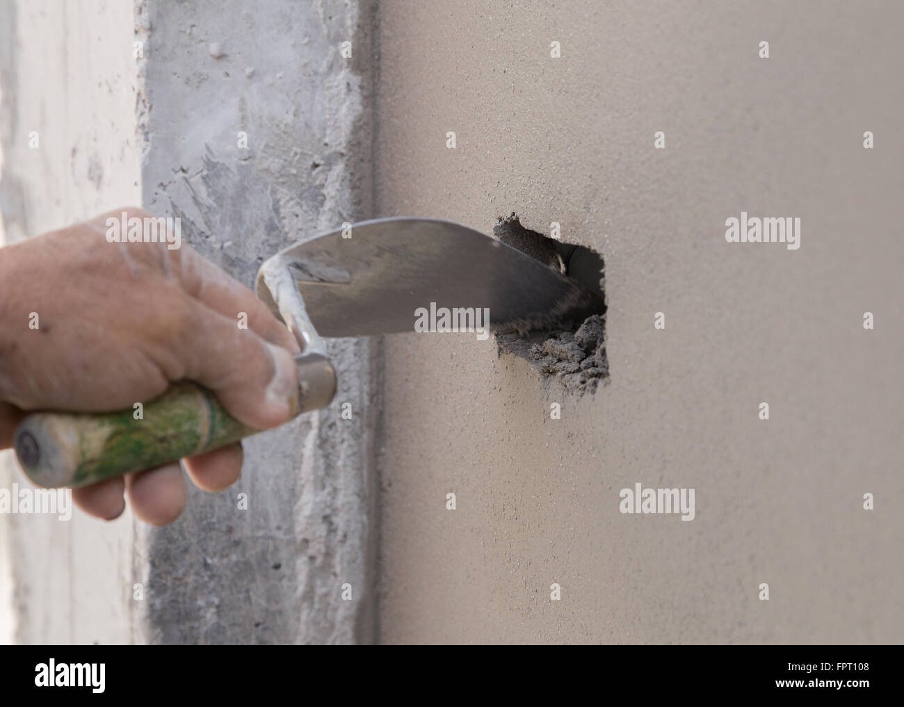 Close-up of hand using trowel to finish wet concrete wall at ...