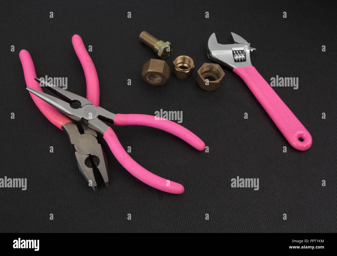pink spanner and wrench on a black surface Stock Photo - Alamy