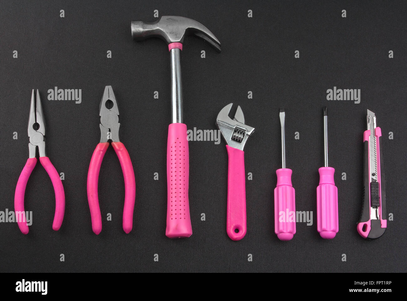 pink pincher, hammer, screwdriver, knife and wrench placed on line ...