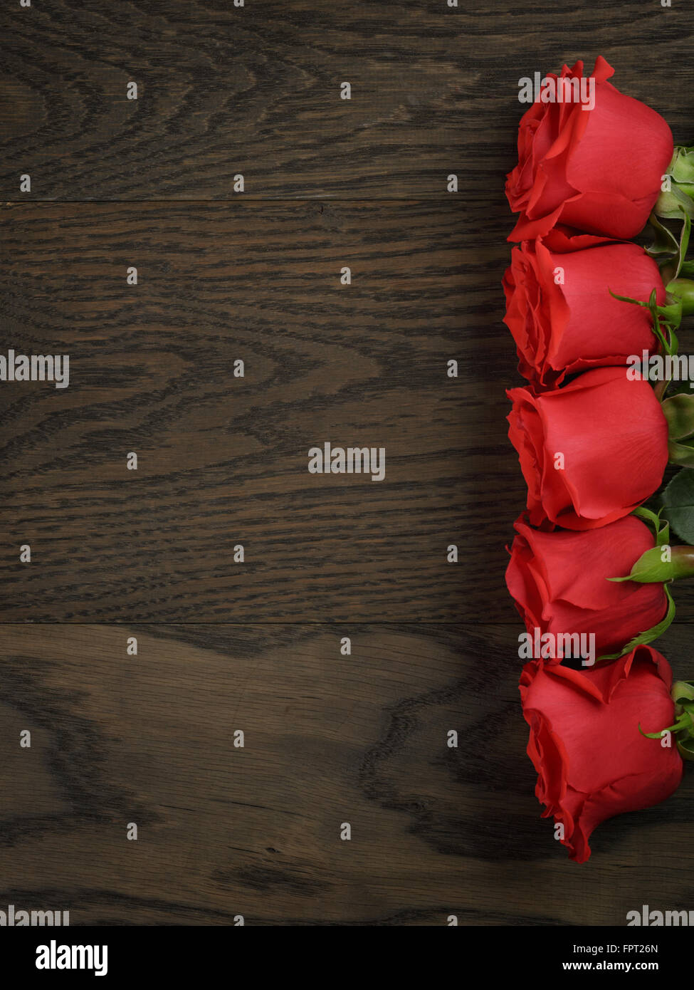 red roses in a row on wood table Stock Photo - Alamy