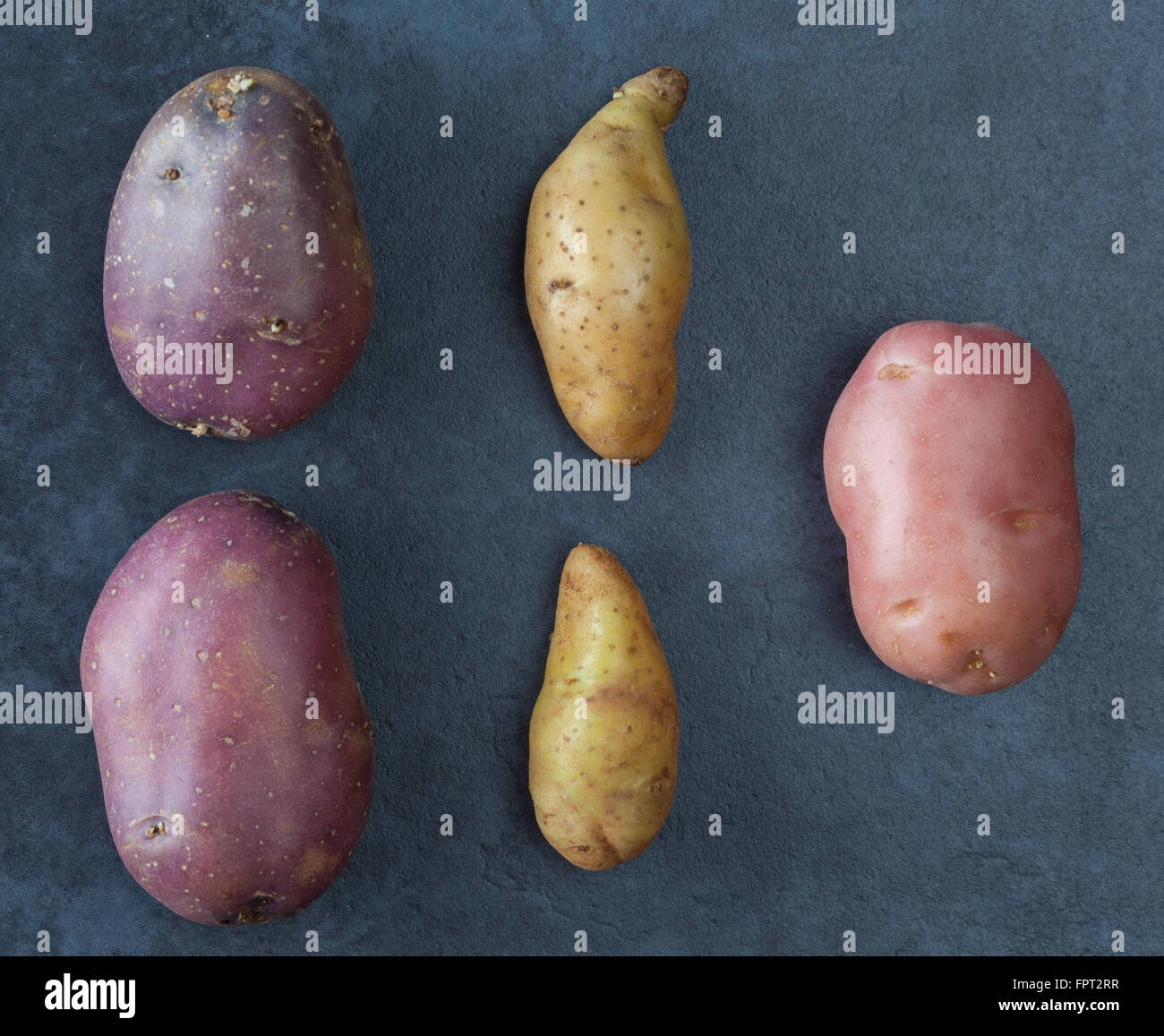 Three kinds of potatoes on dark textured surface. Top view Stock Photo ...