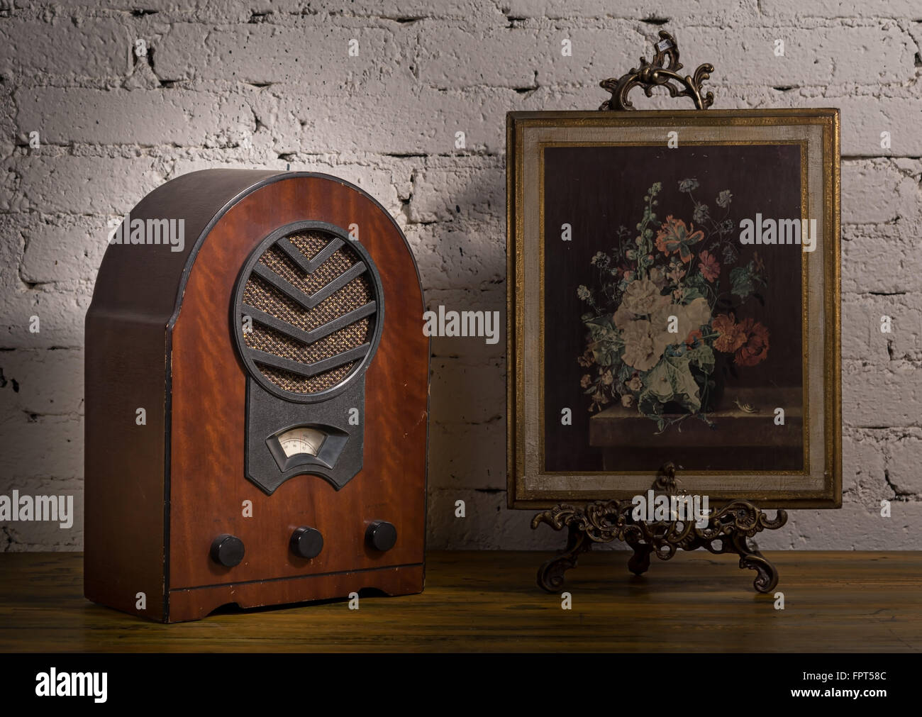 Vintage still life of an old analogue wooden radio and golden framed ...