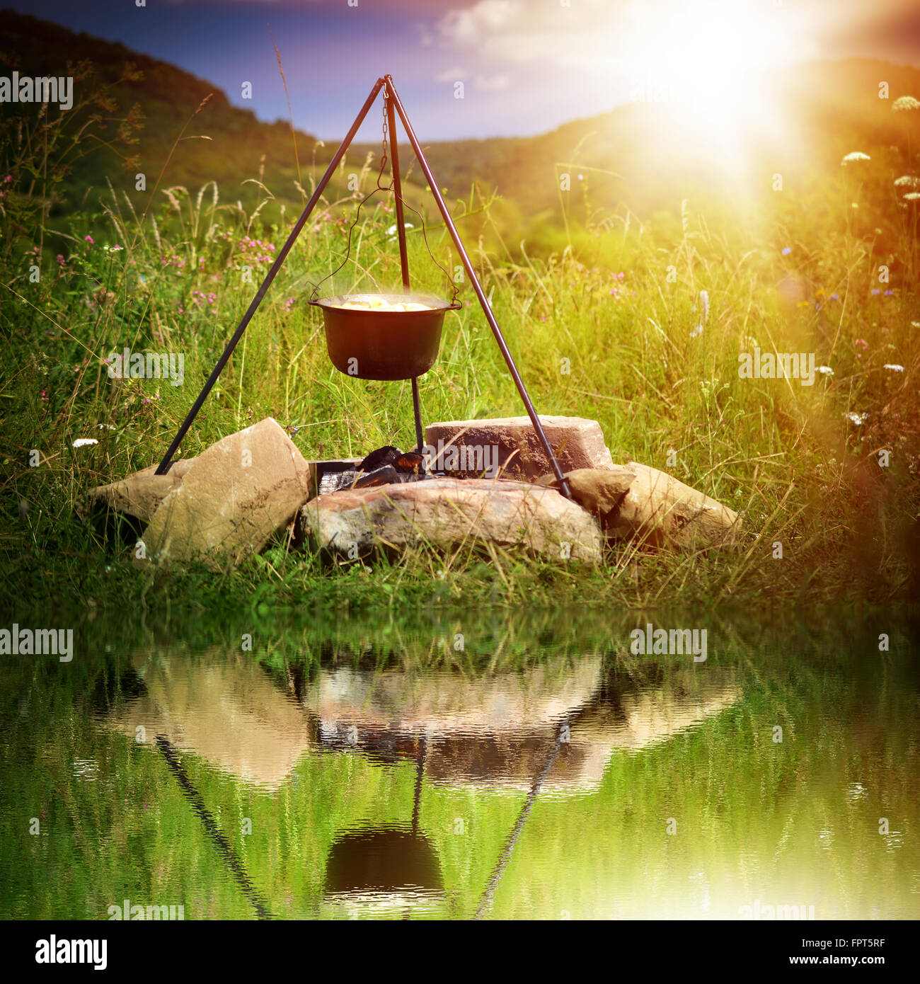 Tourist pot hanging over the fire on a tripod Stock Photo - Alamy