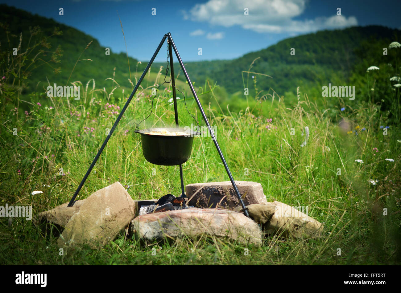 Tourist pot hanging over the fire on a tripod Stock Photo - Alamy