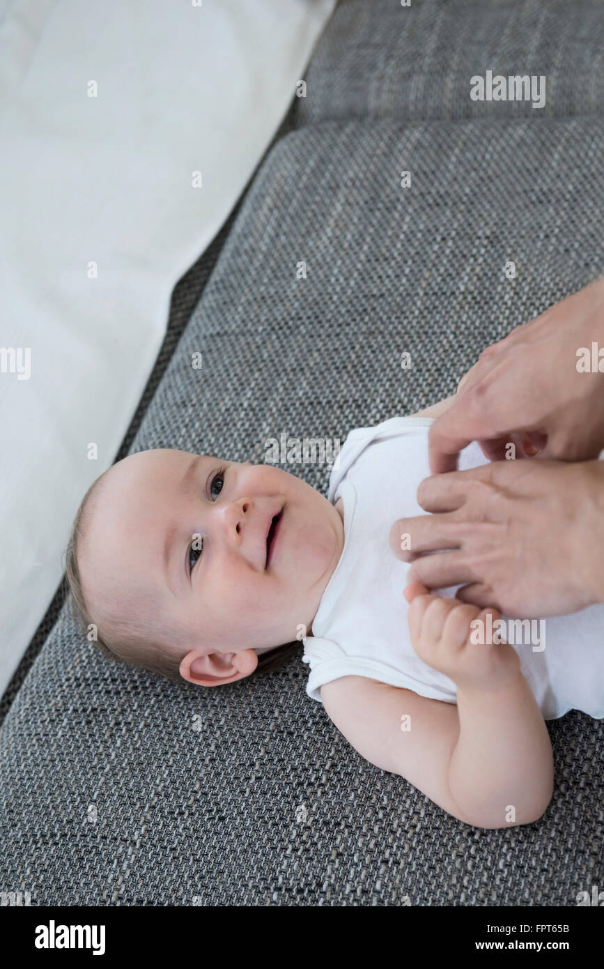Mother tickling her cute baby son in bed, Munich, Bavaria, Germany ...