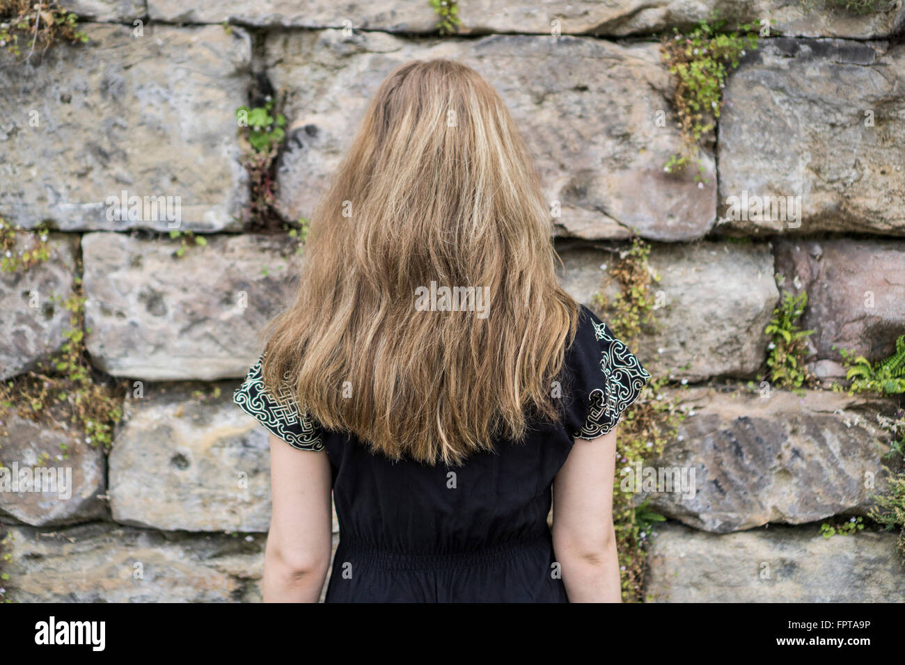 Rear view of a woman facing the wall outdoors Stock Photo - Alamy
