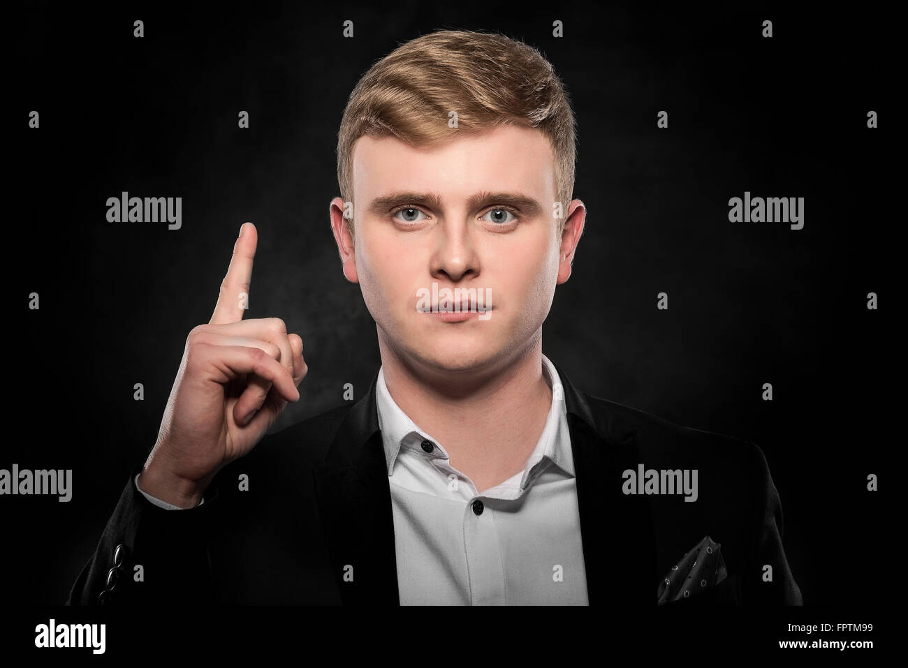 Young man shows finger up Stock Photo - Alamy