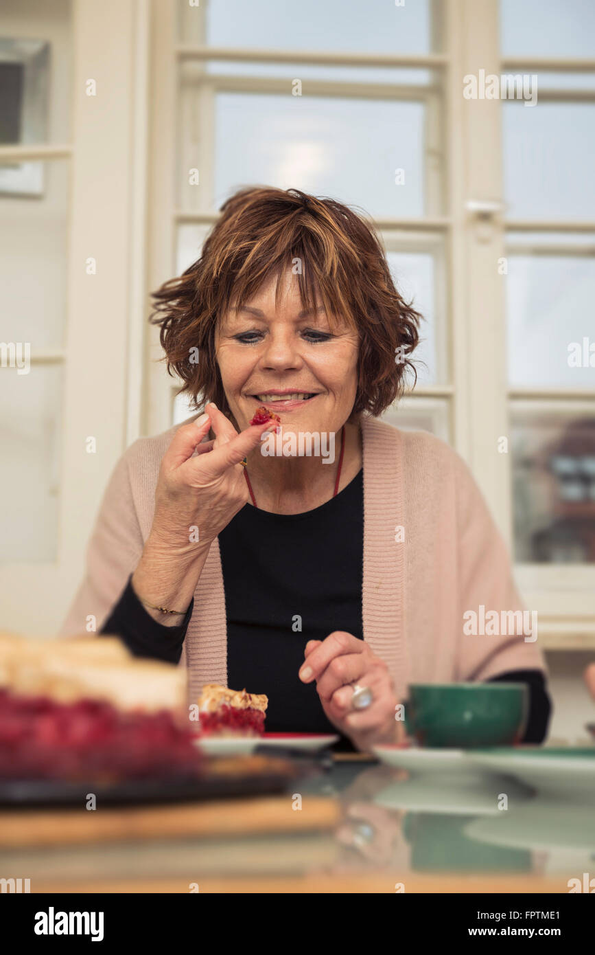 Senior woman tasting and smelling a meringue Cake, Munich, Bavaria ...