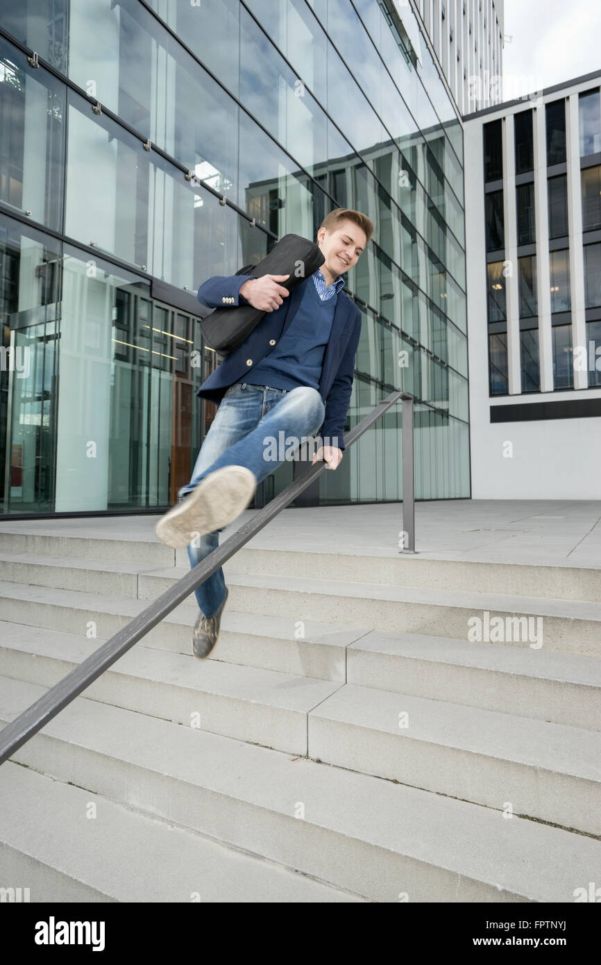 Happy teenagers holding the laptop and jumping railing after work ...