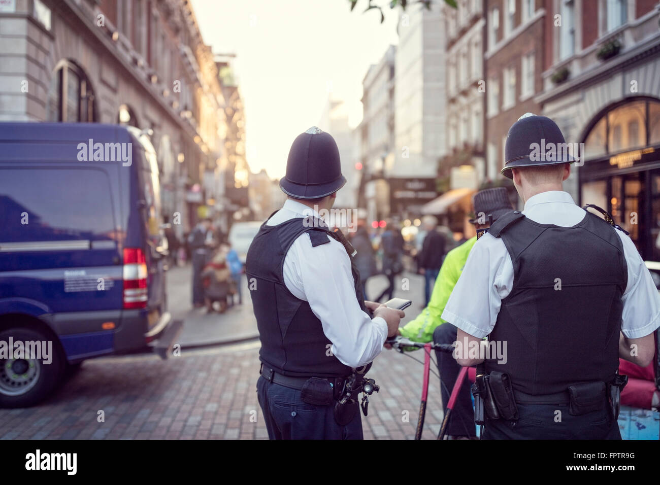British police officers in helmets policing London streets Stock Photo ...
