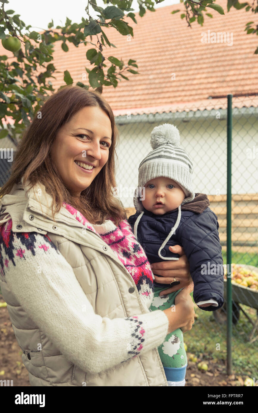 Portrait of a mother holding her baby son in her arms and smiling, Bavaria, Germany Stock Photo ...