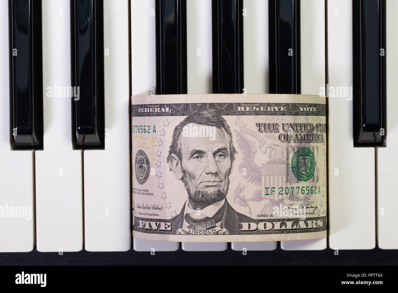 Detail of piano keyboard and US dollar banknote Stock Photo - Alamy