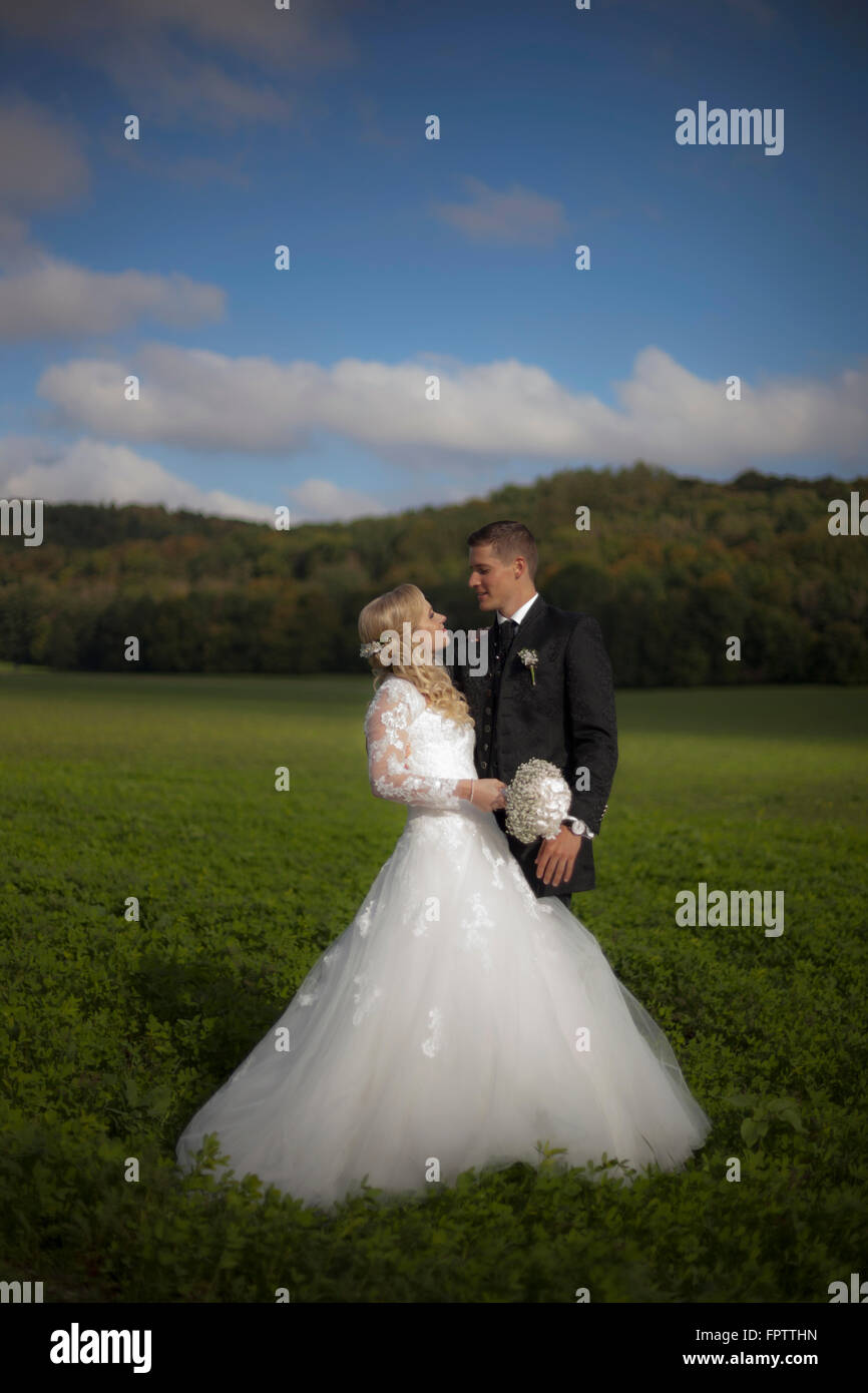 Bride and groom doing romance in field, Ammersee, Upper Bavaria ...