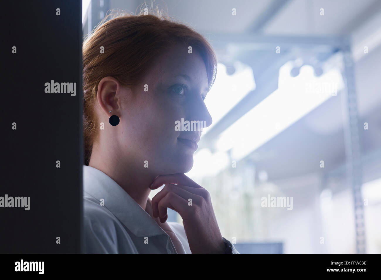 Close up of a young female engineer thinking in an industrial plant ...