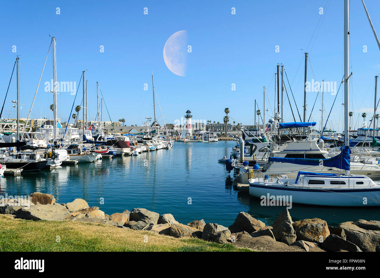 Harbor with large moon over Lighthouse. Boats docked Stock Photo - Alamy