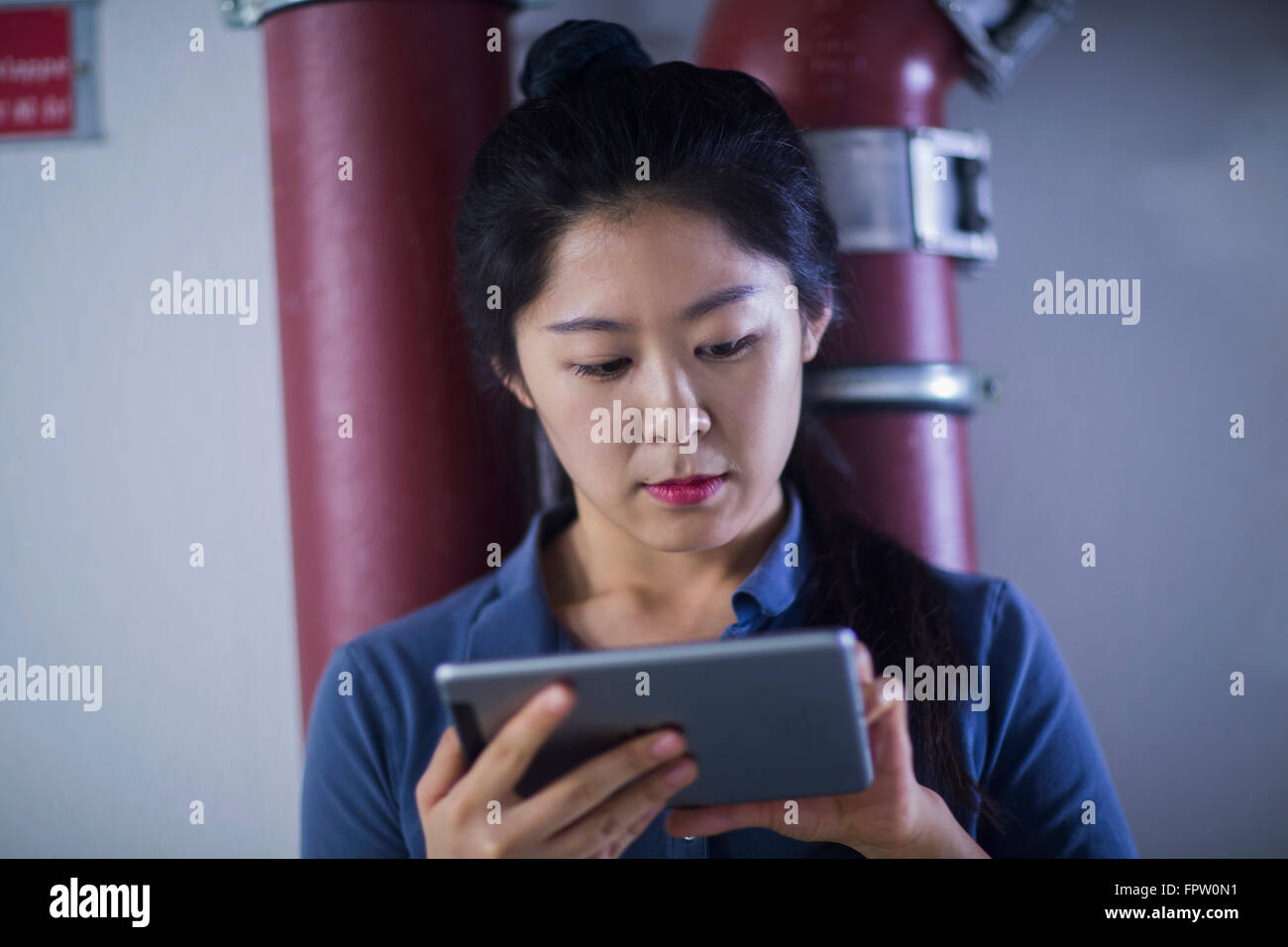 Young female engineer updating control panel by digital tablet in an ...