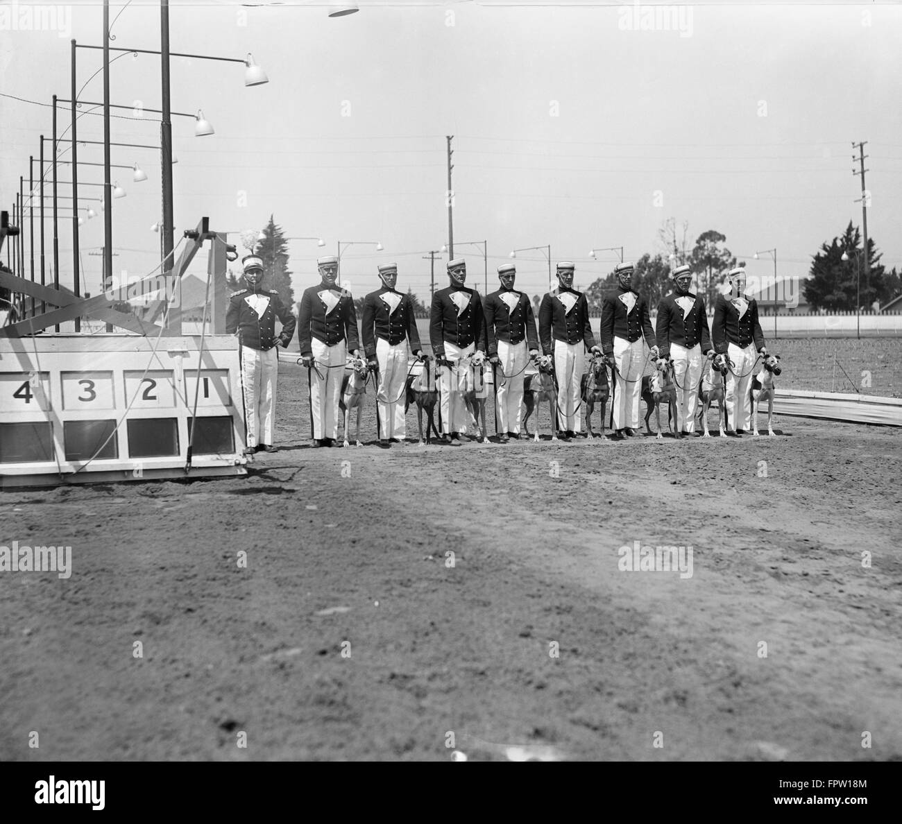 1930s GROUP OF MEN TRAINERS WEARING UNIFORMS STANDING WITH RACING DOGS ...