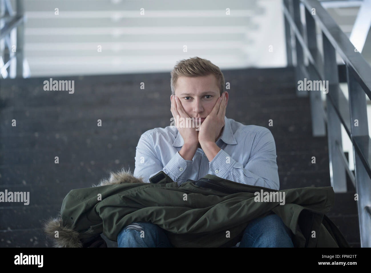 Bored college student sitting alone on staircase, Freiburg im Breisgau ...