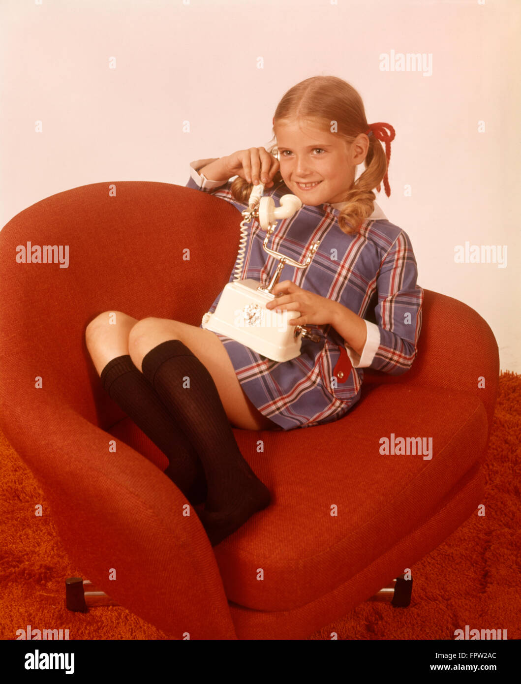 1970s SMILING GIRL KNEE SOCKS PLAID DRESS SITTING RED CHAIR TALKING ... 1970s SMILING GIRL KNEE SOCKS PLAID DRESS SITTING RED CHAIR TALKING ...
