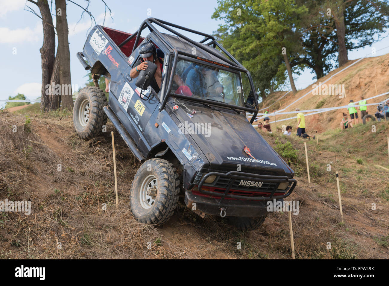 Black off road car is sliding down a steep slope between wooden sticks ...