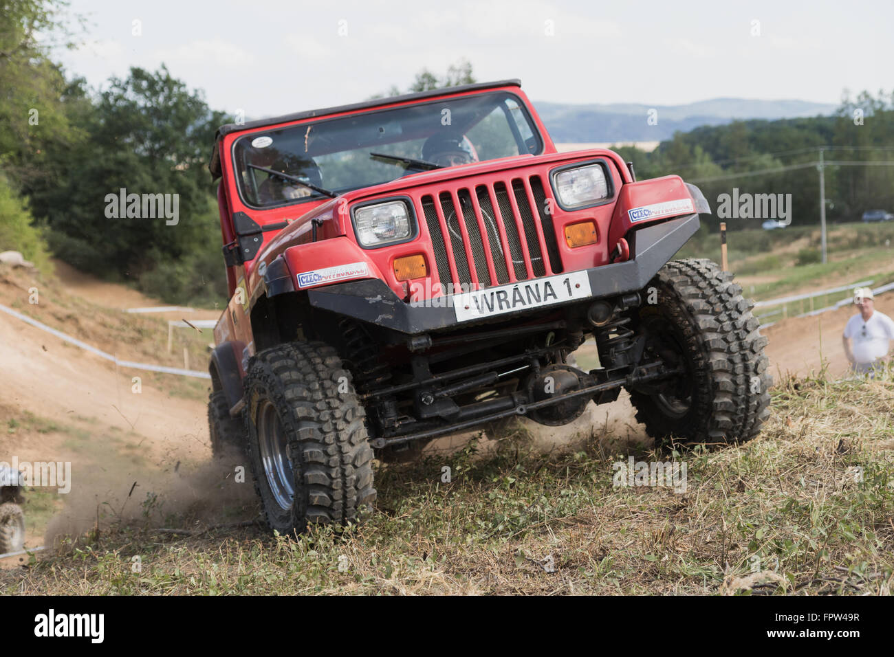 Closeup front view of a red off road car, which is overcoming a ...
