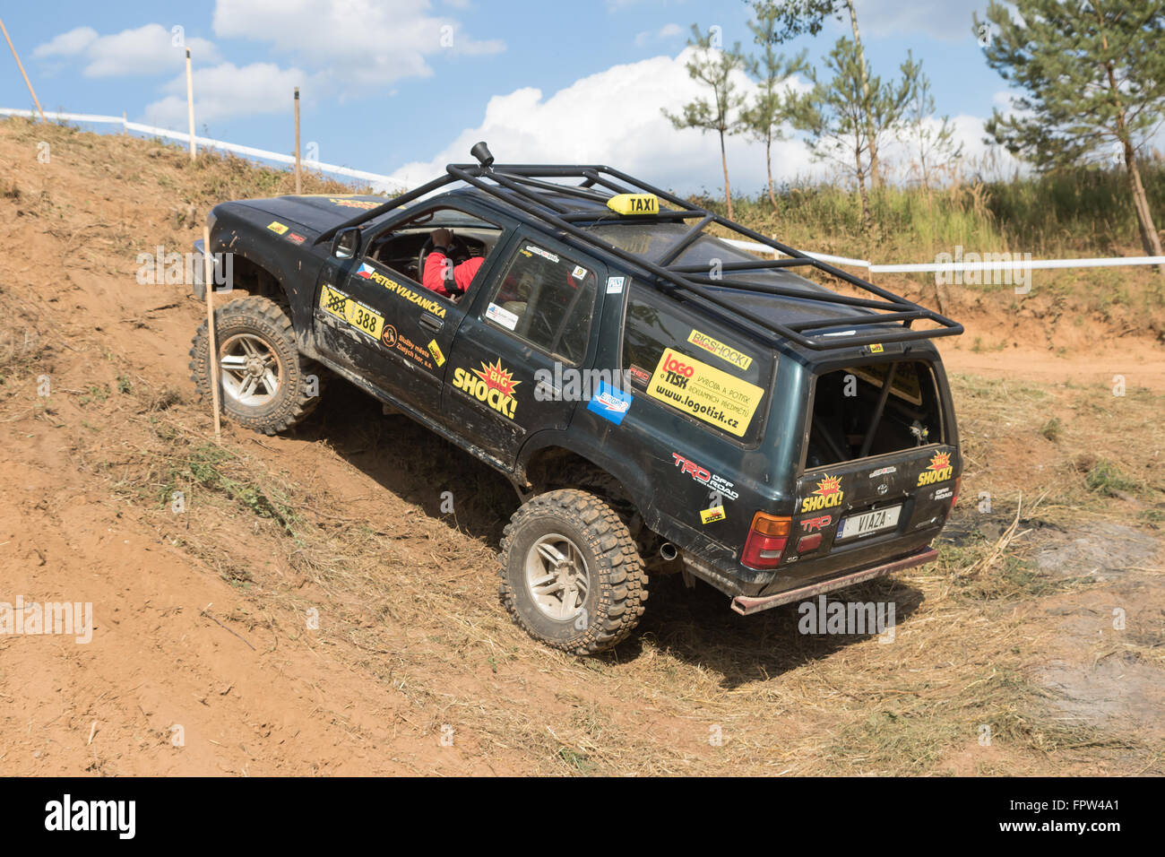 Big black off road car is overcoming a steep slope in defined route ...