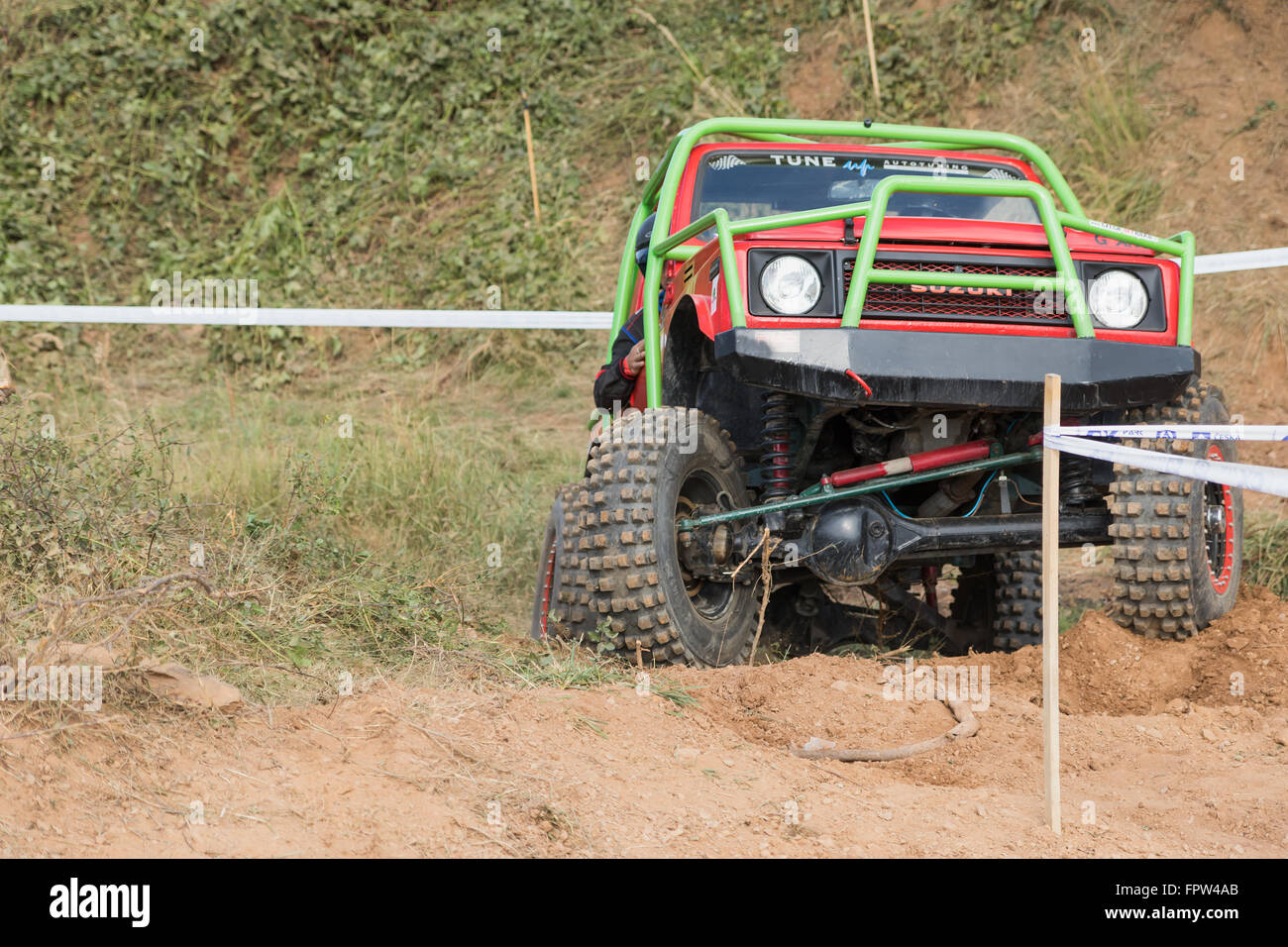 Red and green off road car is is traversing a route at the race Stock ...