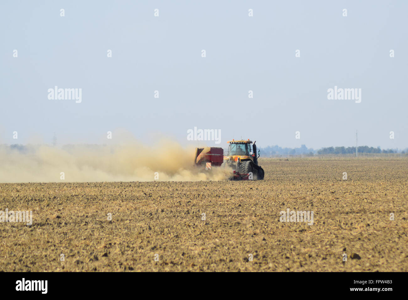 Tractor rides on the field and makes the fertilizer into the soil ...