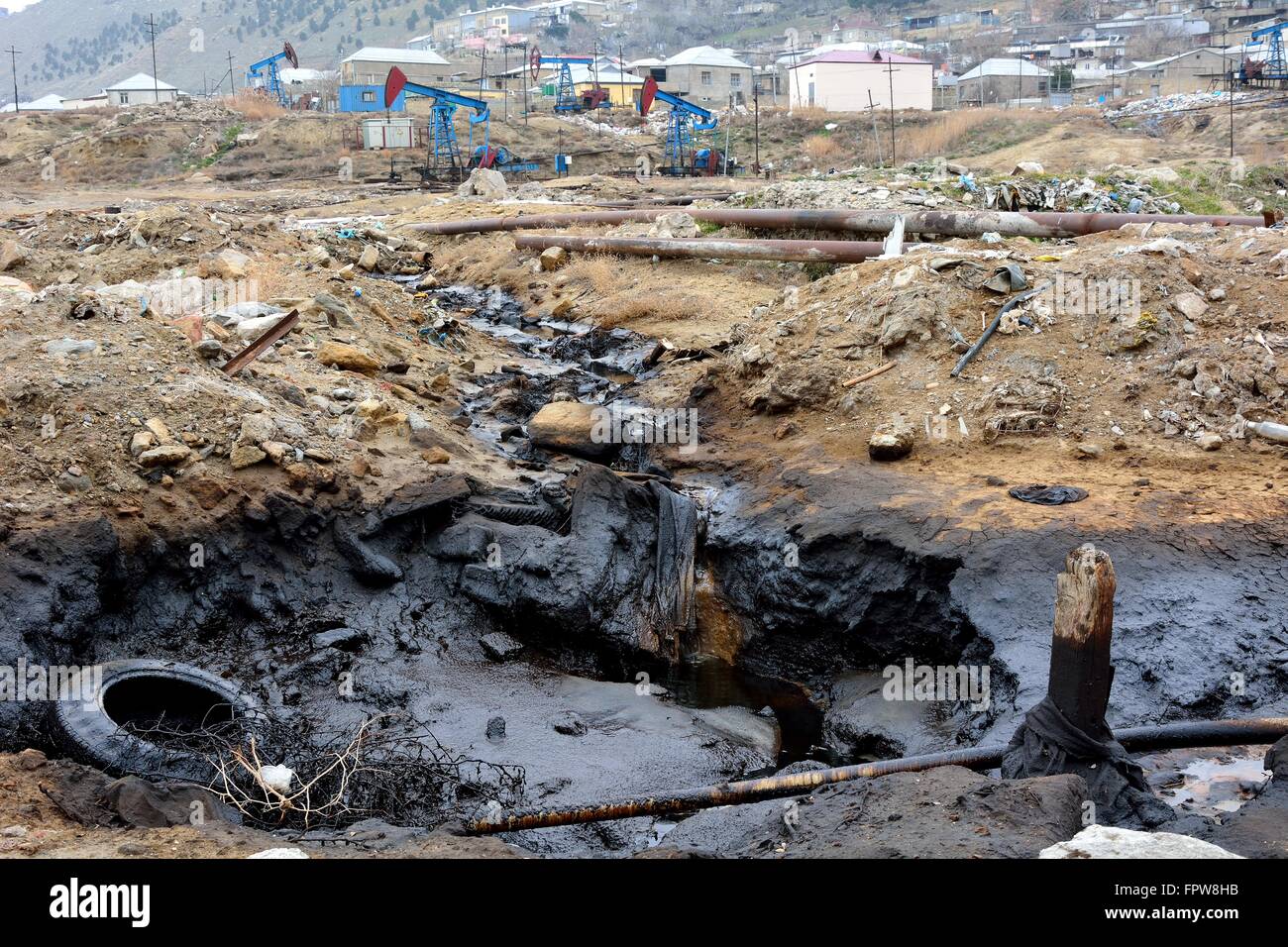 Oil pollution flowing from pumps on-shore in Baku, Azerbaijan. A black ...