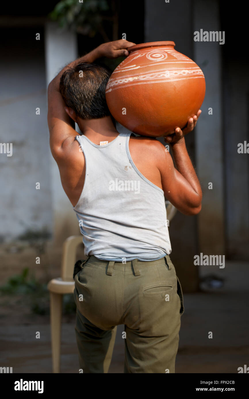 Man carrying pot on shoulder Stock Photo - Alamy