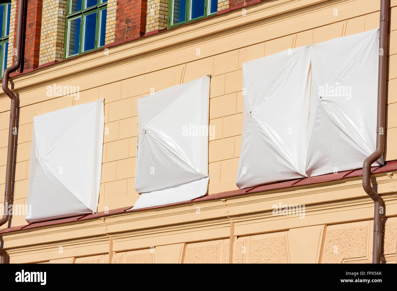 A temporary weather seal cover the windows on a building as the windows ...
