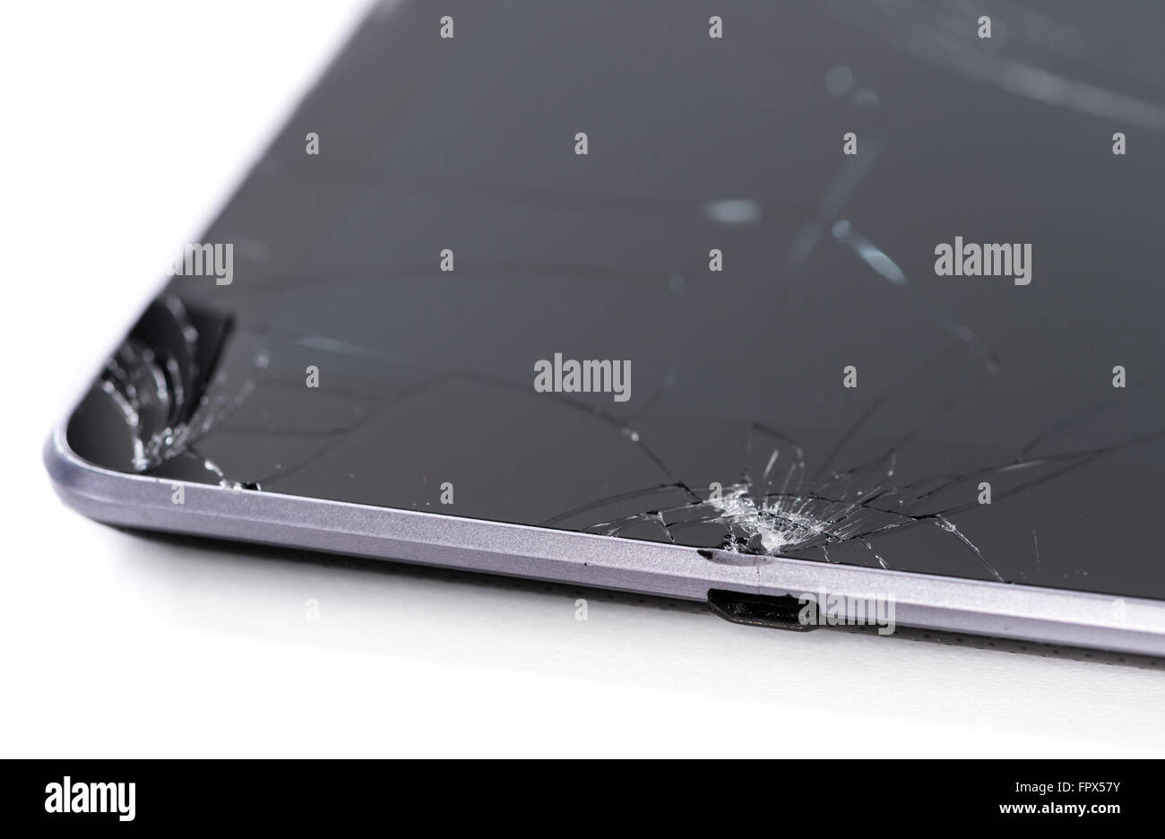 A broken tablet computer as detailed close-up shot on neutral white ...