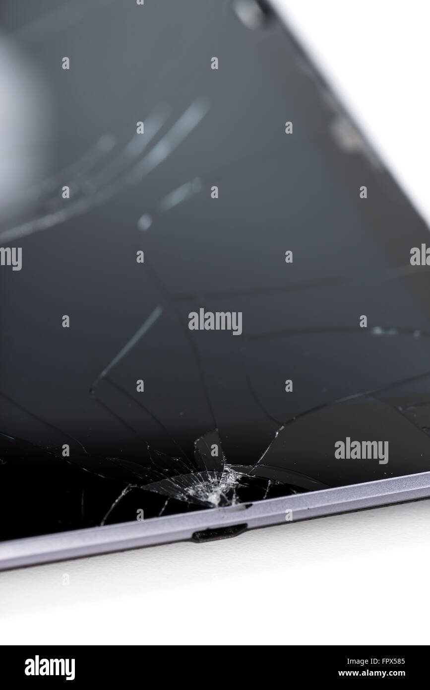 A broken tablet computer as detailed close-up shot on neutral white ...