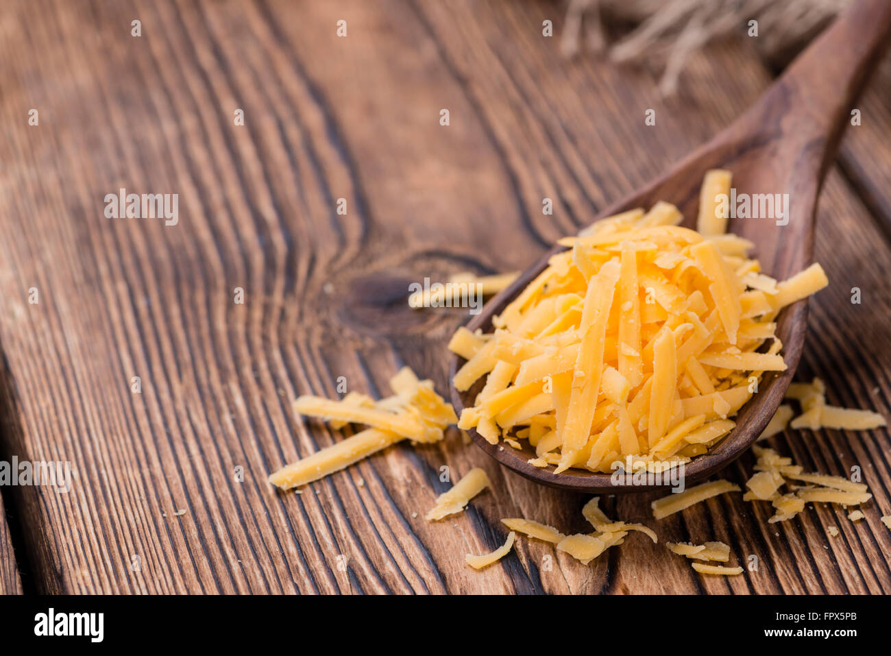 Portion of grated Cheddar Cheese on rustic wooden background Stock ...