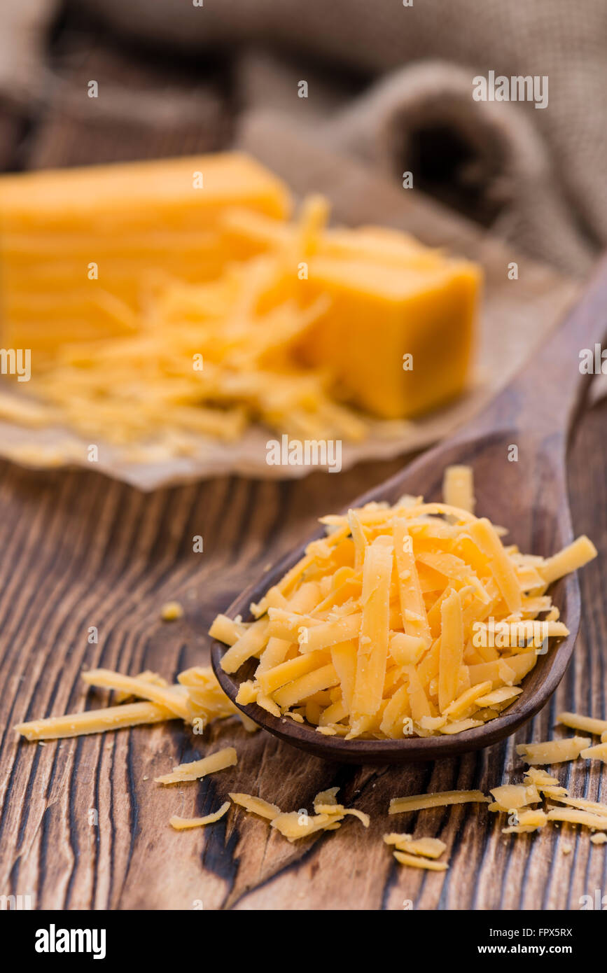Portion of grated Cheddar Cheese on rustic wooden background Stock ...