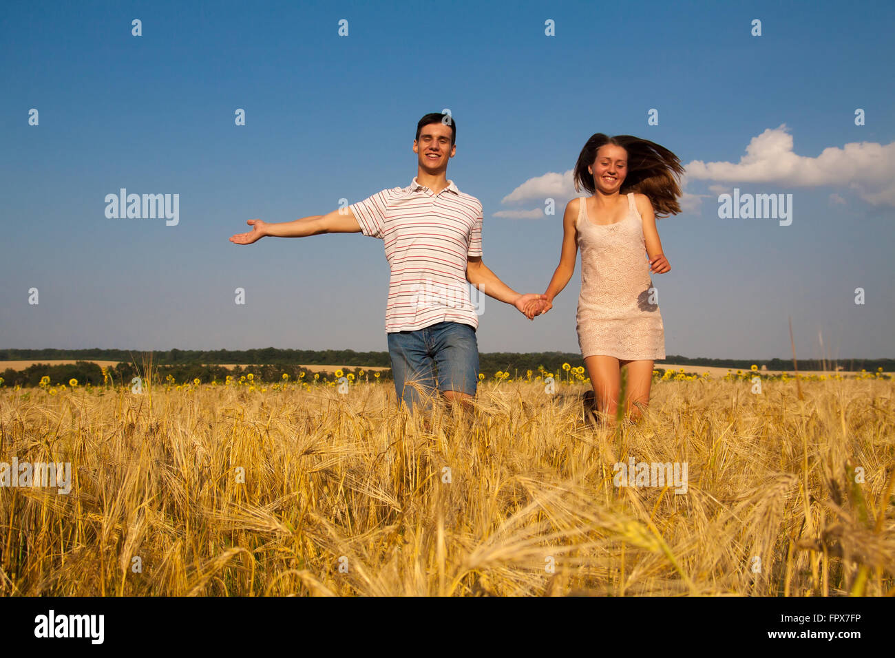 Young couple runningthrough wheat field Stock Photo - Alamy
